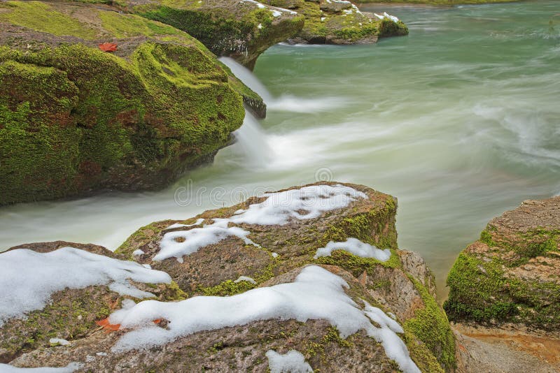 Snow on Mossy Rocks beside Smooth Cool Flowing River Water Stock Photo ...