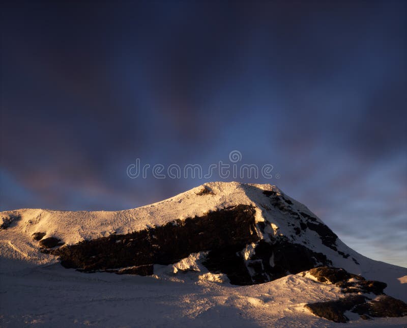 Snow Mountain at Sunset Under a Blue Sky with Clouds. Stock Photo ...