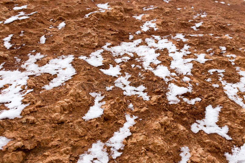 Snow on red clay in nature stock image. Image of ground - 107692433