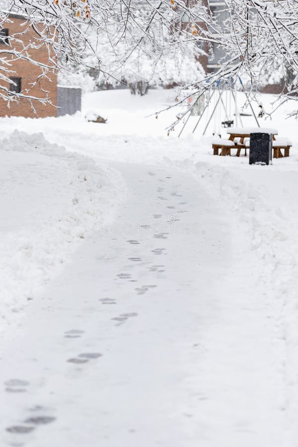 Footprints on a Snowy Road in Winter Season. Snow on the Sidewalk ... Footprints on a Snowy Road in Winter Season. Snow on the Sidewalk ...