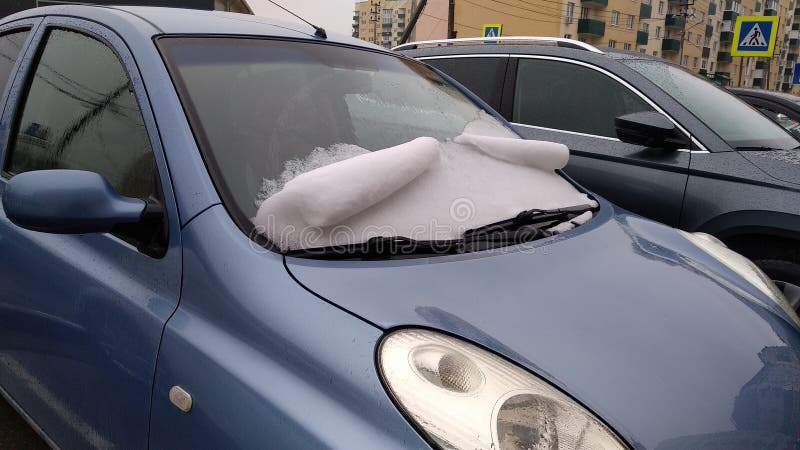 Snow Slides Over the Windshield of a Purple Car with Large Headlights ...