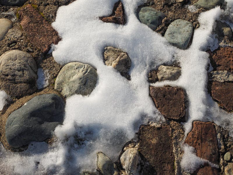 Stones In The Snow Along A Path With A Stone Wall Lining The River ...