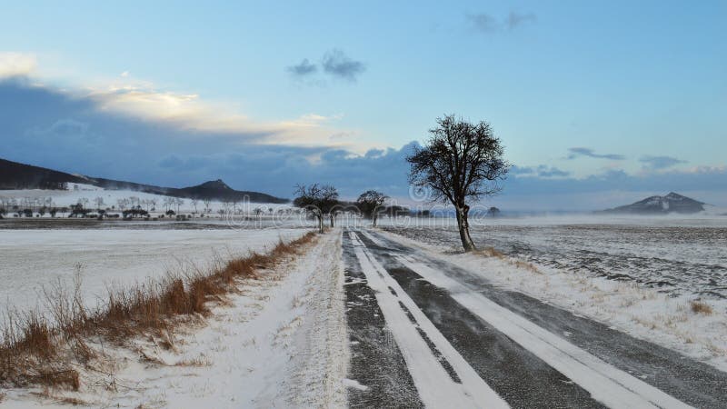 Snow on Country Road with Tree Wind Blowing Across Fields and Hills ...