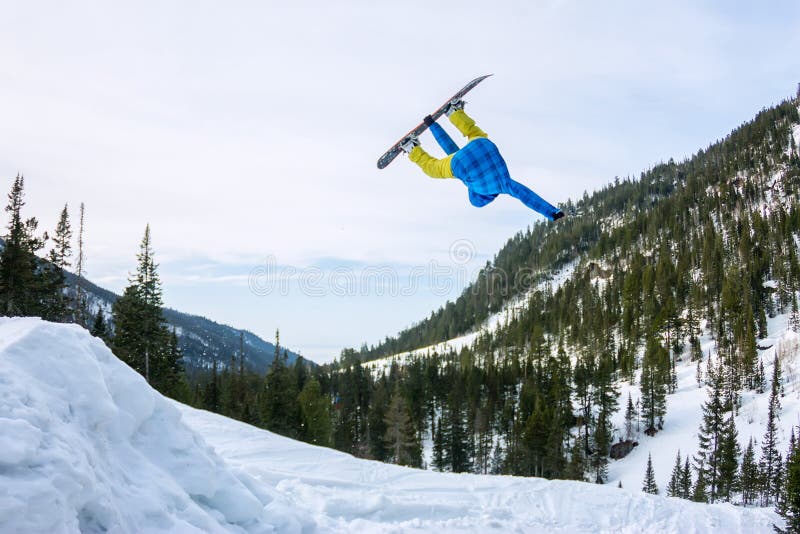 Snowboarder Freerider Jumping from a Snow Ramp in the Sun on a ...