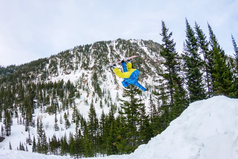 Snowboarder Freerider Jumping from a Snow Ramp in the Sun on a ...