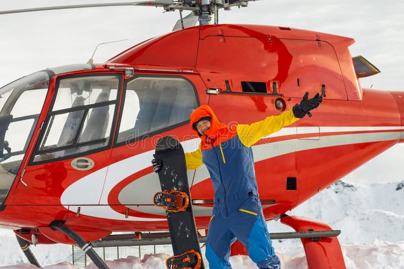 Snowboarder Freerider is Standing at the Helicopter in the Snowy ...