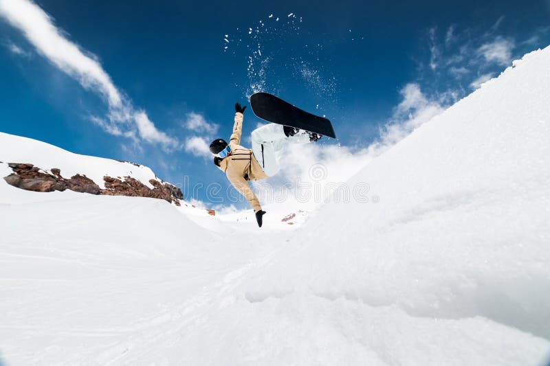 Snowboarder Performs a Trick in a Jump, Snow Flies Behind the Athlete ...