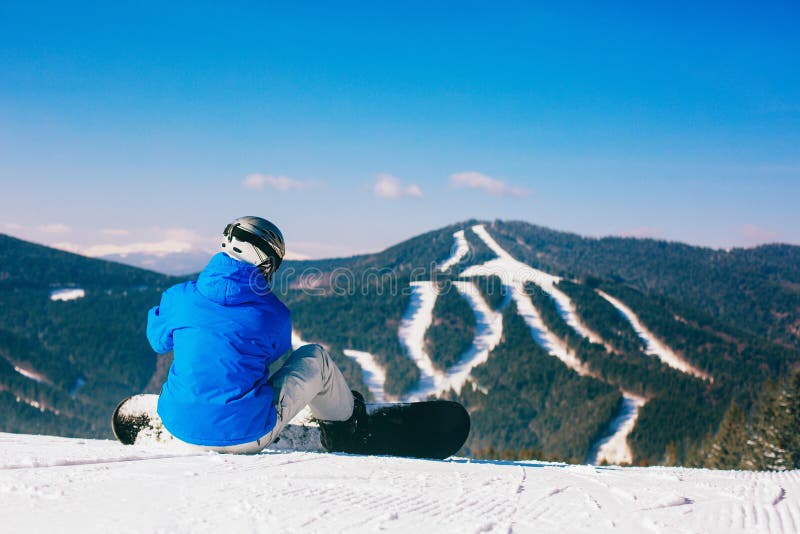 Snowboarder Sitting on Snow Against Mountains Stock Image - Image of ...