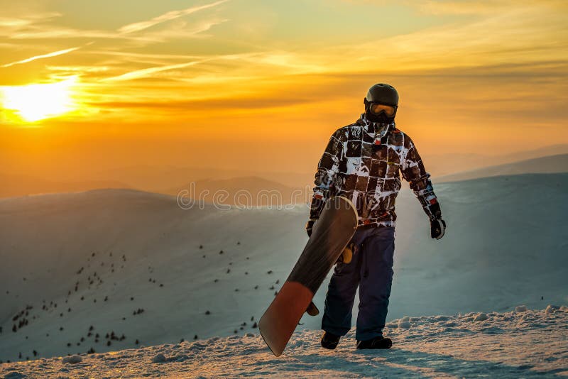 Snowboarder Walking with Snowboard during Sunset in the Mountains Stock ...