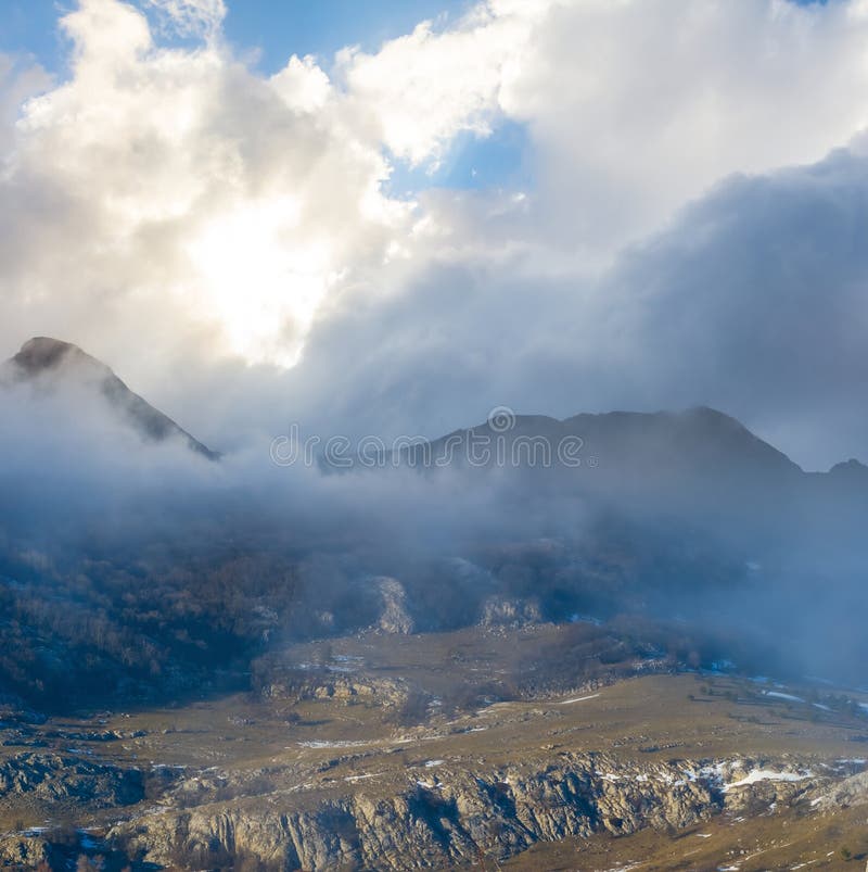 Snowbound Mountain Valley in Dense Mist and Clouds Under a Sparkle Sun ...