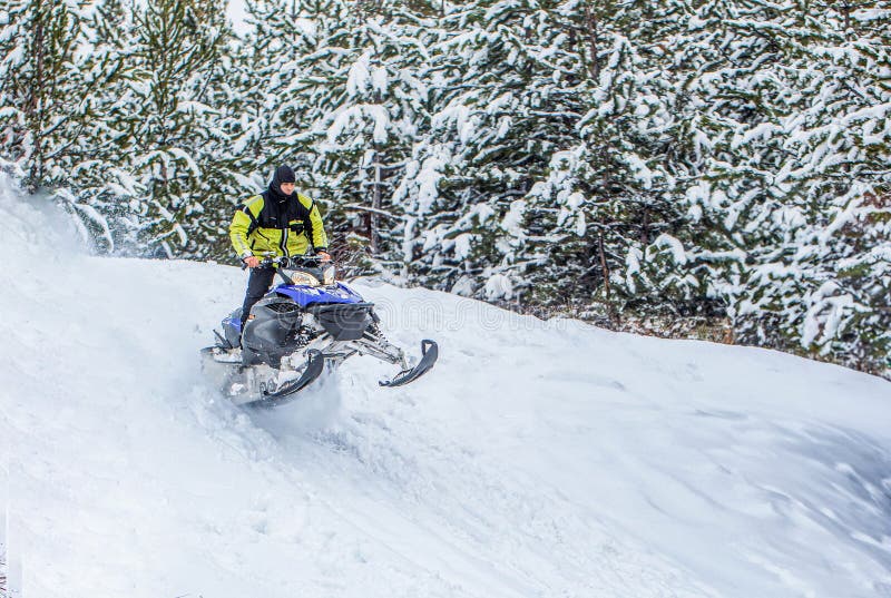 Snowmobile Moving in the Winter Forest in the Mountains. Man and Fast ...