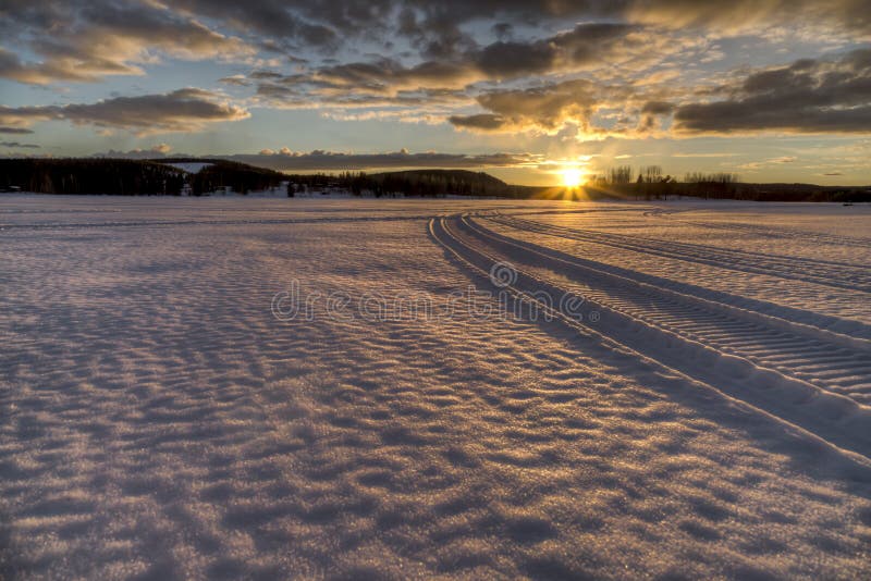 Snowmobile Tracks Heading into the Sunset Stock Image - Image of trail ...
