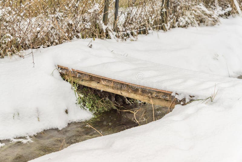 Snowy Bridge Over a Stream Covered with Ice Stock Photo - Image of snow ...