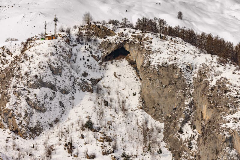 Snowy Cliff with Cave and Sparse Trees Stock Image - Image of ...