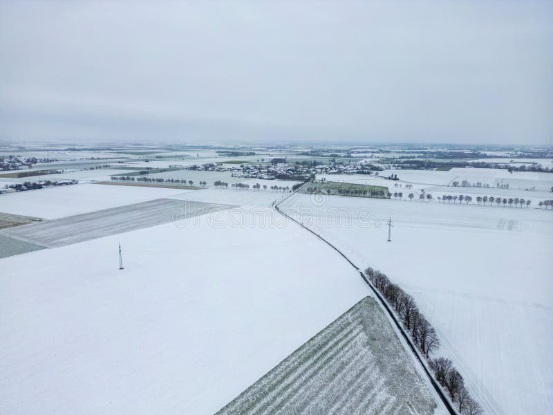 A Snowy Field with a Road in the Middle Stock Image - Image of scenic ...