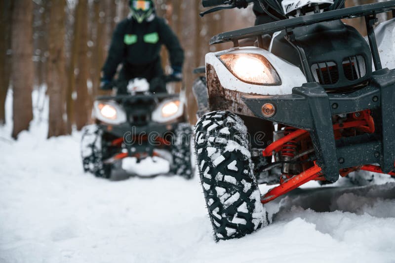 On the Snowy Ground. Two People are Riding ATV in the Winter Forest ...