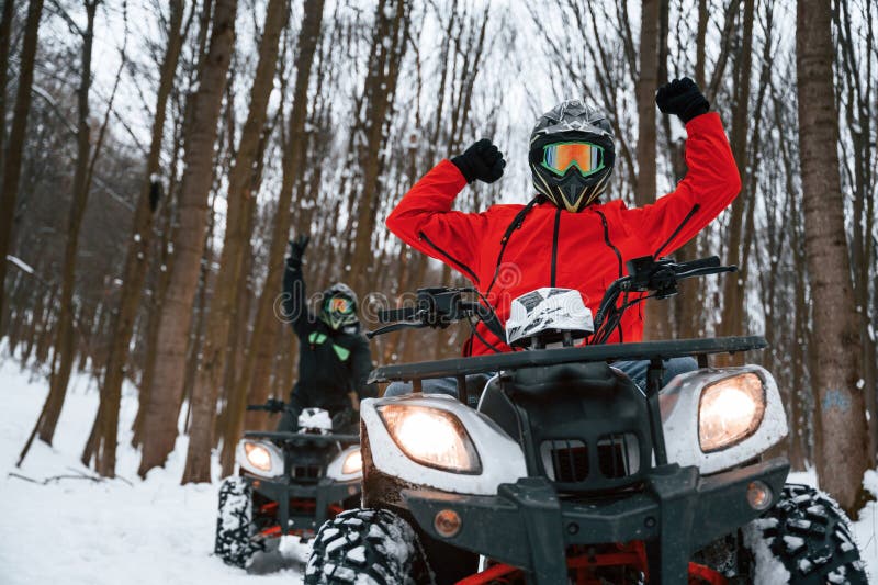 On the Snowy Ground. Two People are Riding ATV in the Winter Forest ...