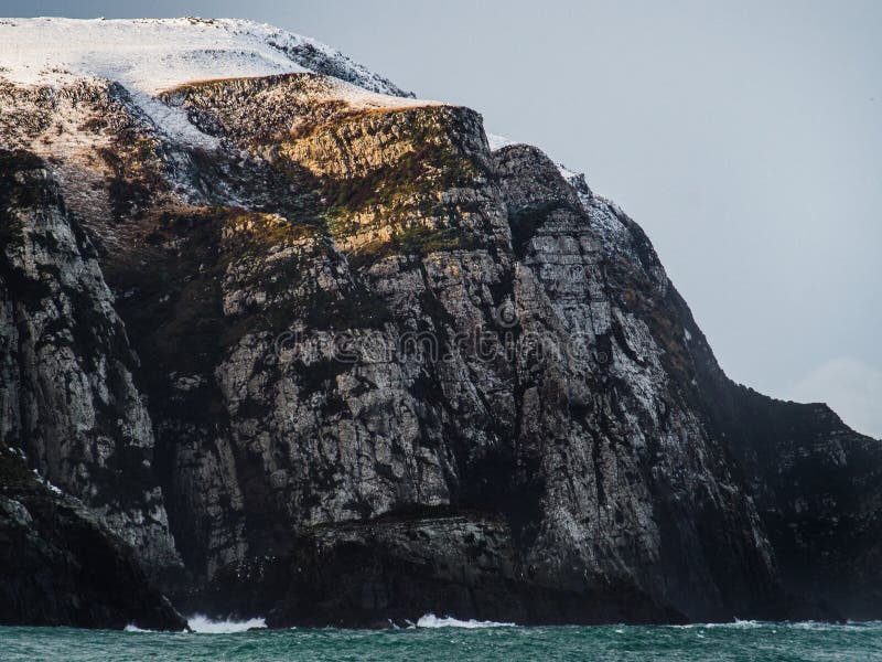 Snowy Mountain Cliffs Over Ocean Stock Image - Image of rock, snowy ...