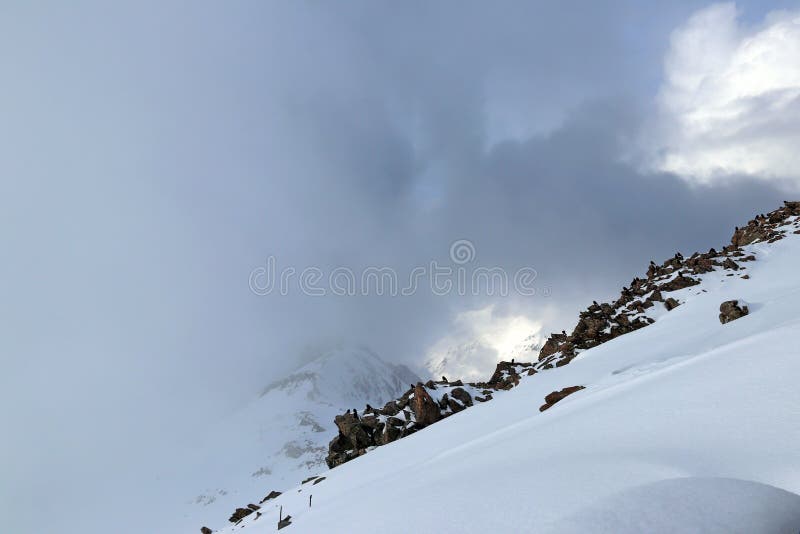 Snowy Mountain Side with Stones and Birds in the Clouds Stock Image ...