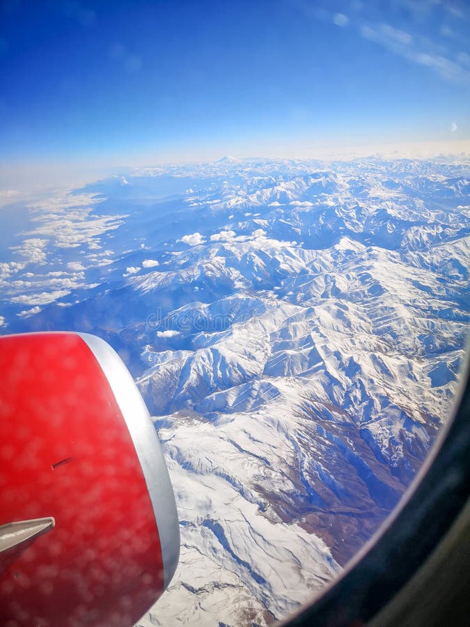 Snowy Mountains with Clouds As Background. View from the Airplane ...