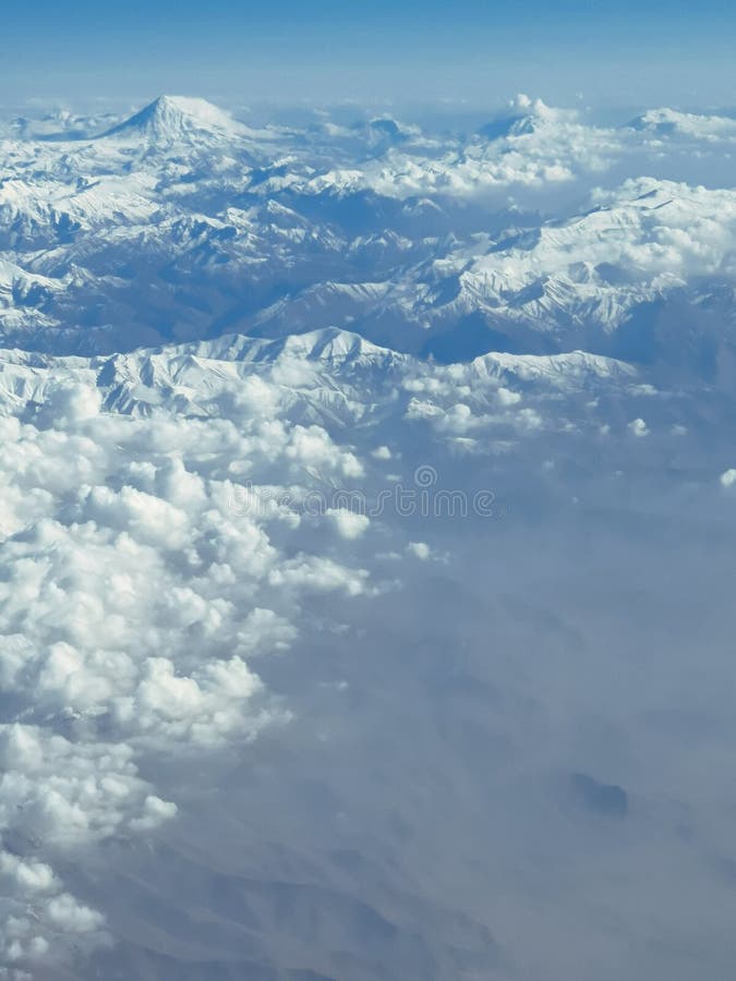 Snowy Mountains with Clouds As Background. View from the Airplane ...