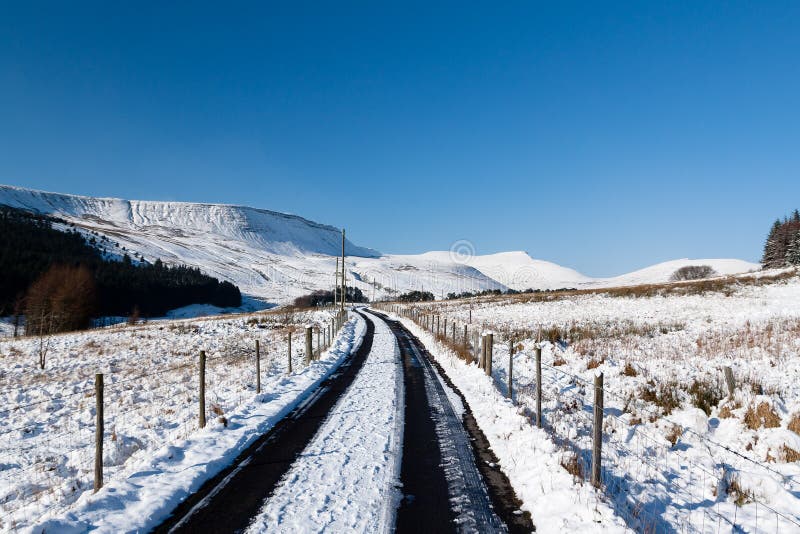 A Snowy Track Leads Towards Snow Capped Mountains Stock Image - Image ...