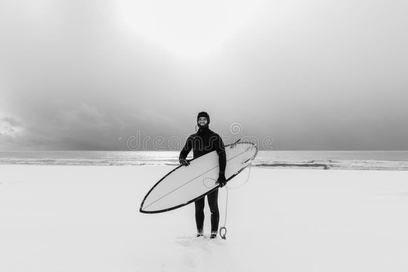 Snowy Winter and Surfer with Surfboard. Winter Beach and Surfer in ...