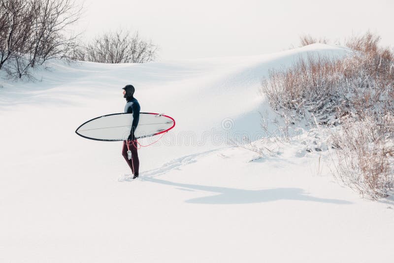 Snowy Winter and Surfer with Surfboard. Winter and Surfer in Wetsuit ...
