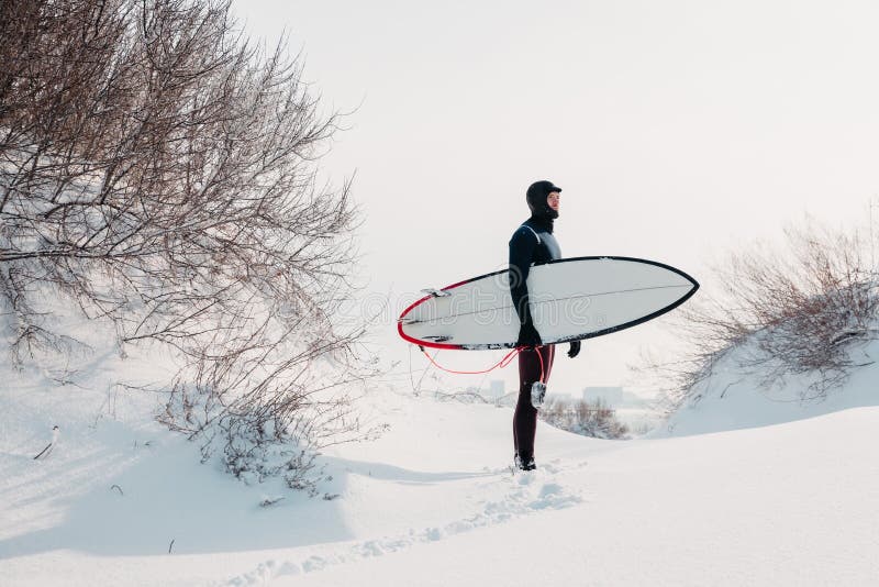 Snowy Winter and Surfer with Surfboard. Winter and Surfer in Wetsuit ...