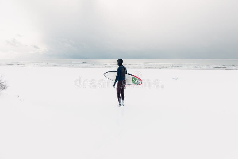 Snowy Winter and Surfer with Surfboard. Winter and Surfer in Wetsuit ...