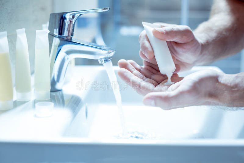Mature Man Purring Some Soap On His Hands While Washing Face Stock