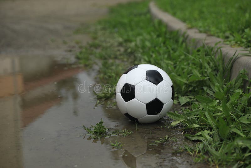 Soccer Ball in Puddle Outdoors, Space for Text Stock Photo - Image of ...