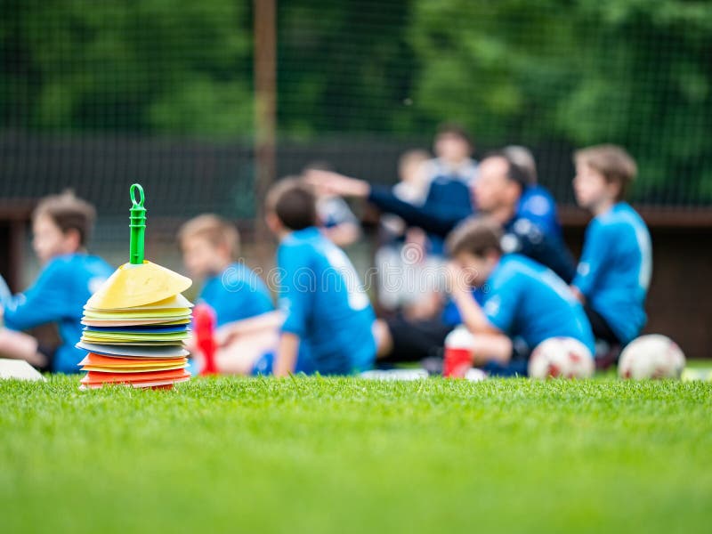 Soccer Players Rest Sitting between Cone Markers on Green Stock Photo ...