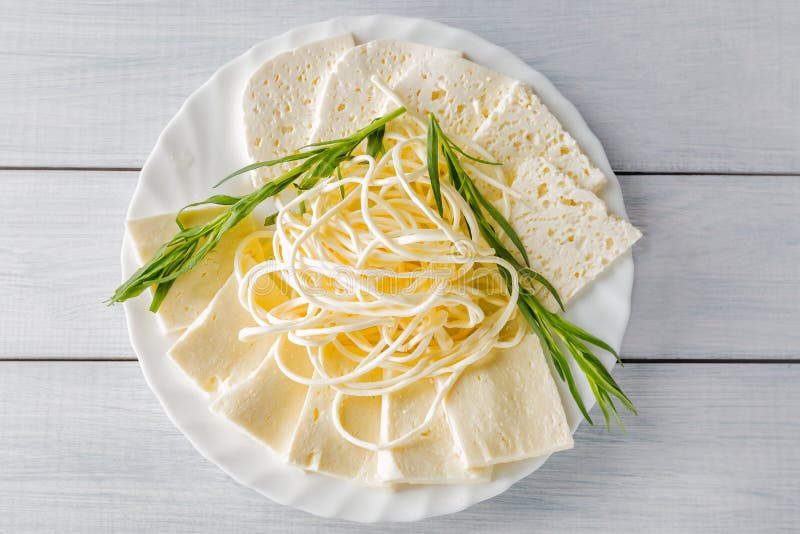 Soft Cheese Chechil and Guda on Plate with Herbs on Wooden Table. Top ...