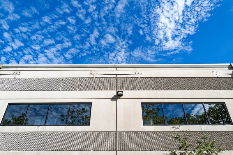 Soft Clouds Hover Above the Facade of a Modern Office Building Stock ...