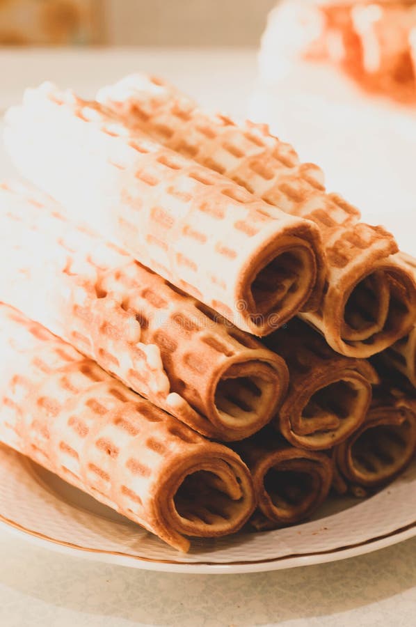 Crispy Rolled Waffles in Stack on Parchment Paper and White Plate at ...