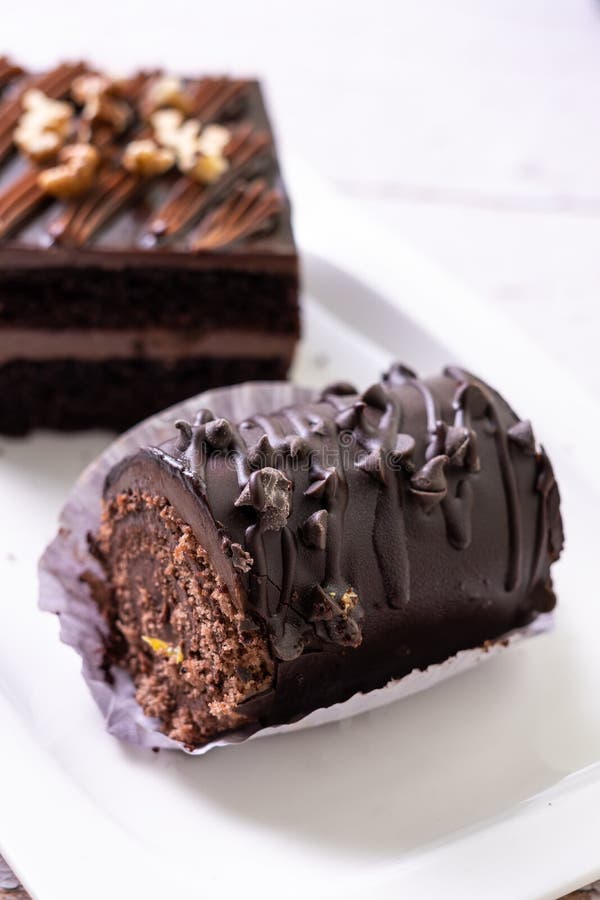 Soft Focus of a Mini Chocolate Cake Roll and a Square Slice of Cake in ...
