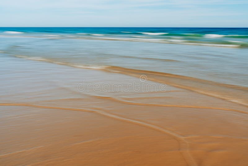 Soft Focus Seashore with Gentle Waves and Blurred Reflections. Stock ...