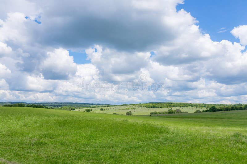 Green Valley with Low Hills Beneath a Deep Sky Filled with Dramatic and ...