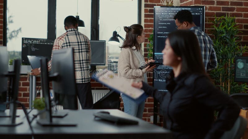 Software Developer Holding Digital Tablet Analyzing Code on Wall Screen ...