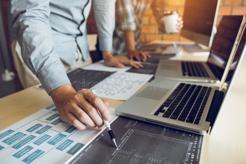Software Developer Holds the Pen Pointing To the Computer Screen and is Analyzing the Code Stock ...