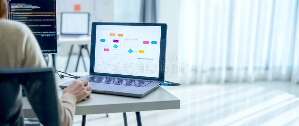 Software Developer Reviews UX UI Design Diagrams while Coding at a Workstation Stock Image ...