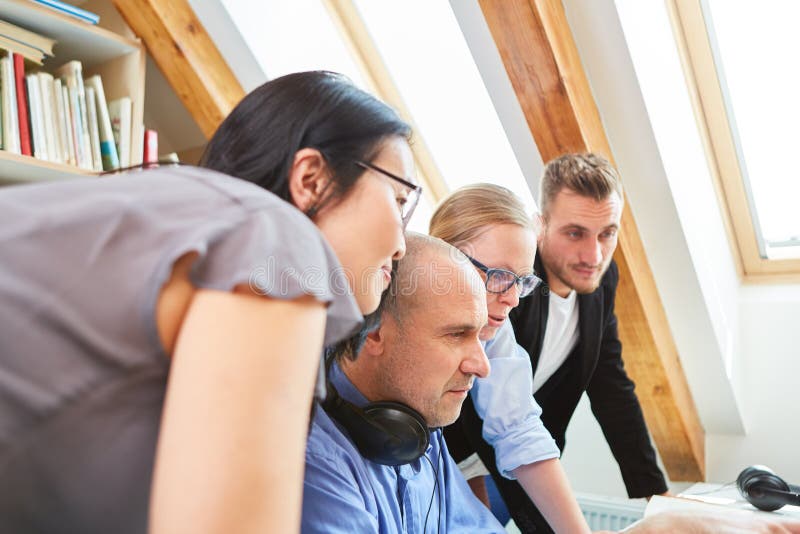 UI Developer Team Consulting on Their Project with Tablet and Paperwork ...