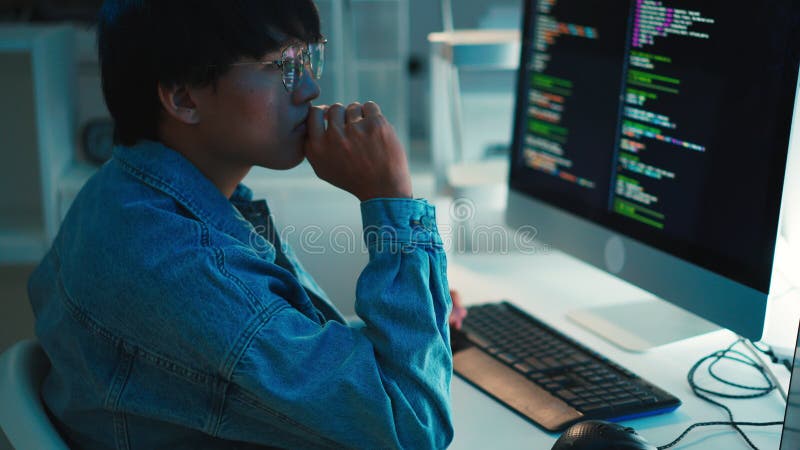 Software Developer Using Keyboard Focused on Debugging Programming Code on Dual Monitor Setup ...
