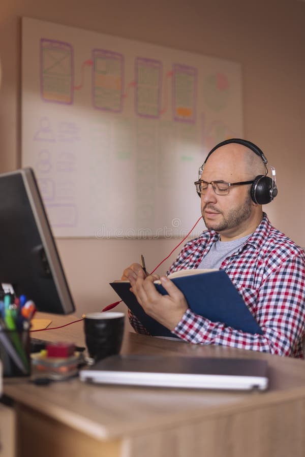 Software Developer Writing in Planner while Having Morning Briefing ...