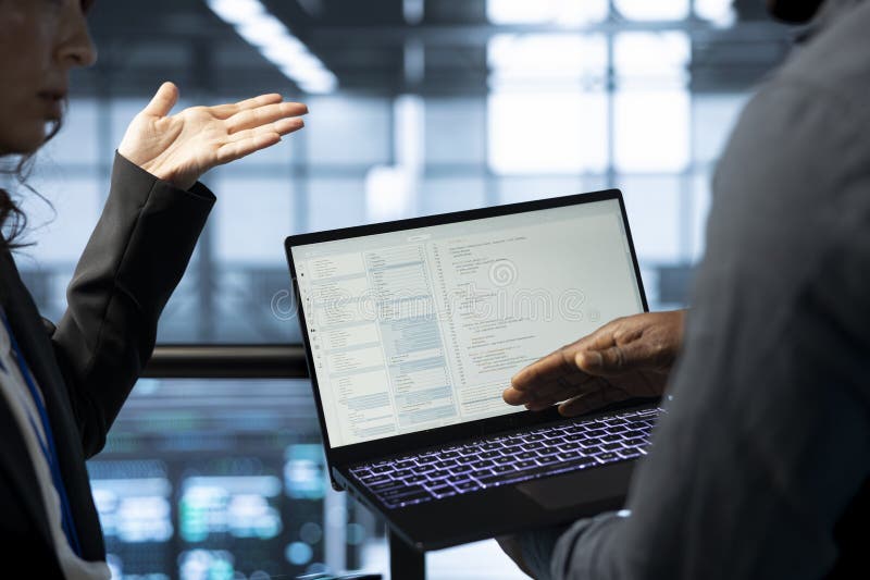 Software Developers Using Laptop In Data Center Managing Server