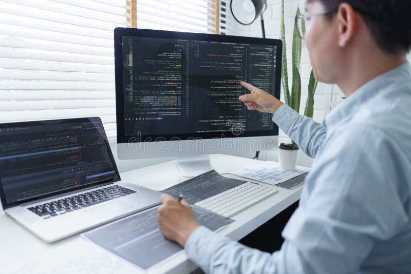 Software Development Concept, Male Programmer Checking Data Codes on Document and Computer ...