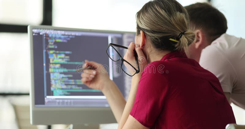 Software Engineers Analyzing Code on Wall Screen Tv Looking for Bugs and Errors while Colleague ...
