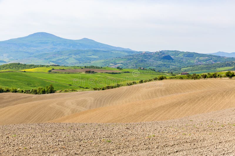 Soil Field in a Rolling Landscape with Mountains in the Background ...