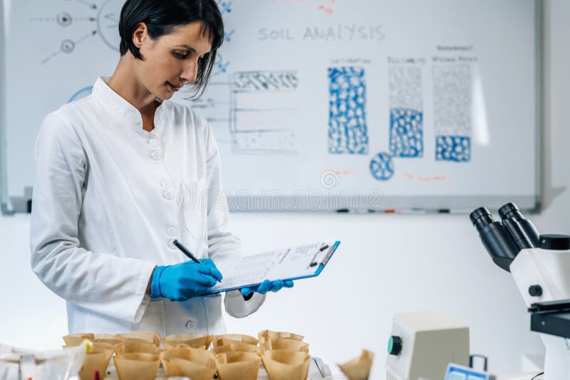 Soil Samples Testing Laboratory. Female Biologist Taking Notes in ...